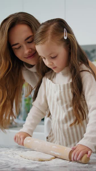 Tender mother helping daughter kitchen vertically closeup. Child rolling dough - Stock Video ...