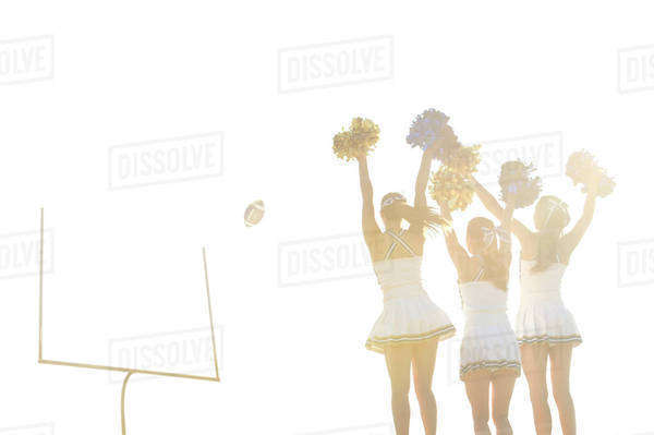 Caucasian cheerleaders on sidelines at football game - Royalty-free ...