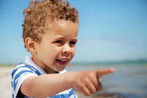 Adorable little kid pointing at something interesting outdoors ...