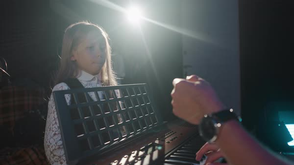 Girl acquires skill of singing in studio. Tiny pupil practices vocal ...