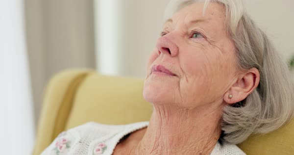 Senior woman, face and thinking on sofa at home to remember sad memory and relax in retirement ...