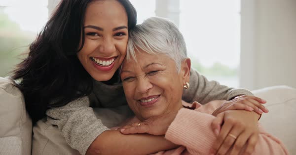 Happy, hug and face of woman with senior mother on sofa for bonding together in the living room ...