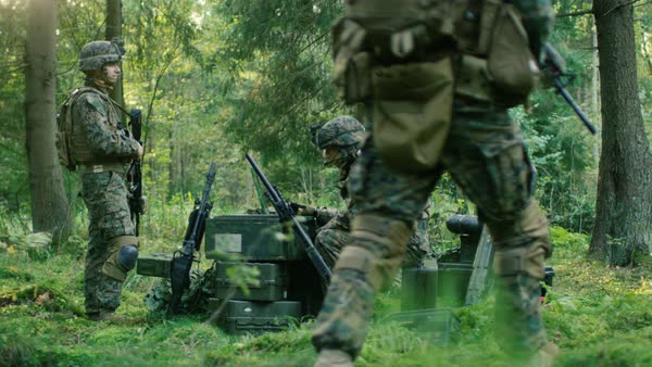 Military staging base, chief army engineer sitting on the boxes of ammunition uses army grade ...