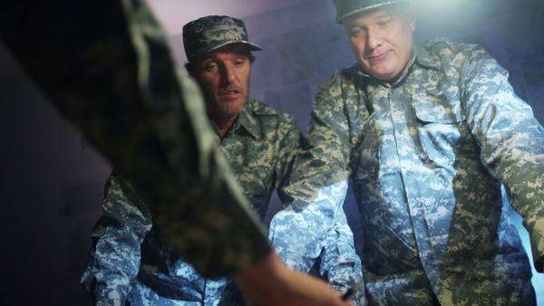Military officers in army bunker, looking at a map and discussing ... Military officers in army bunker, looking at a map and discussing ...