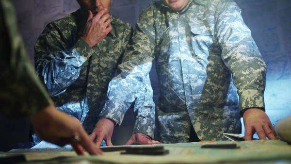 Military officers in army bunker, looking at a map and discussing ... Military officers in army bunker, looking at a map and discussing ...