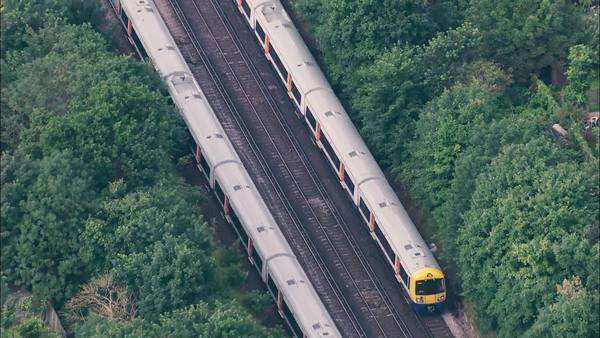 Aerial view of two passenger trains passing by each other in opposite direction over the suburbs ...