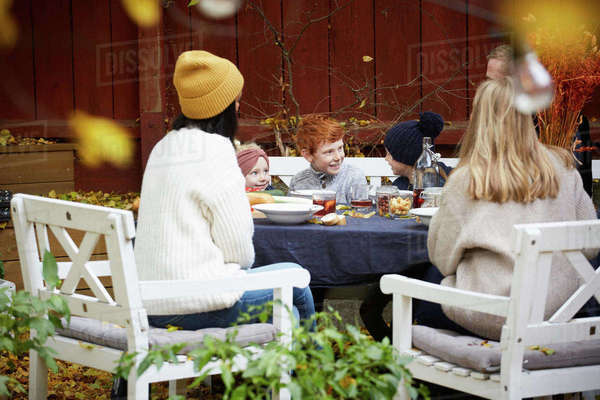 Family and friends sitting at table for social gathering - Stock Photo ...