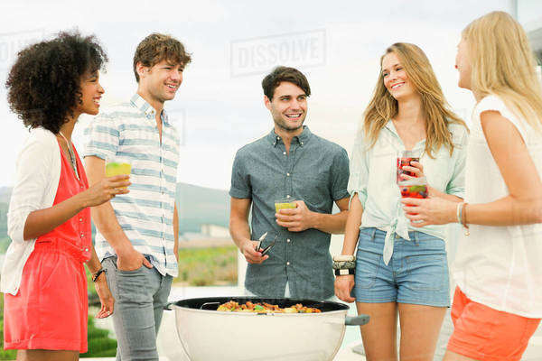 Friends talking at barbecue - Royalty-free Stock Photo | Dissolve