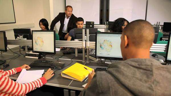 Teacher guiding student in computer class - Stock Video Footage - Dissolve