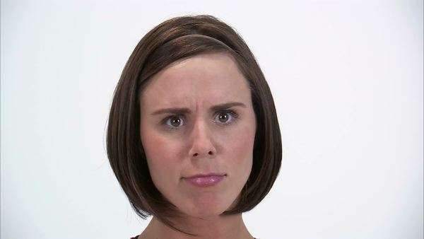 A close-up of a woman giving an over exaggerated agitated expression ...