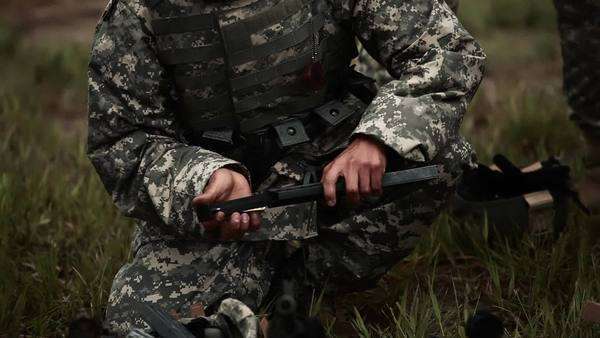 Static shot of soldier loading an assault rifle magazines. Green Beret ...