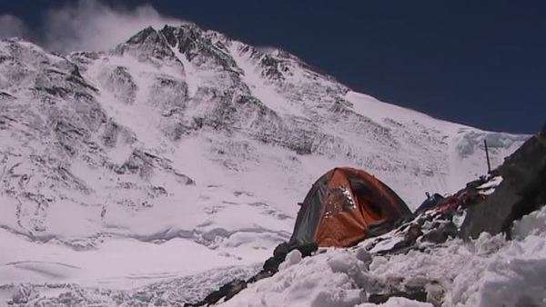 An expedition tent with Mt. Everest pinnacles and the summit in the ...
