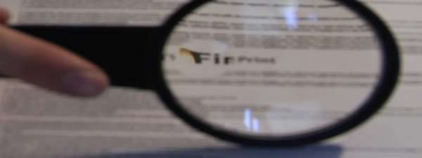 A magnifying glass passes over a paper revealing the words "The Fine ...