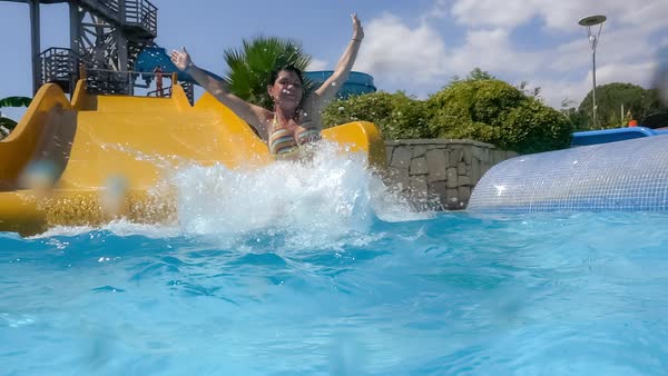 Descent from the waterslide on holiday aqua park. Slow motion on a ...