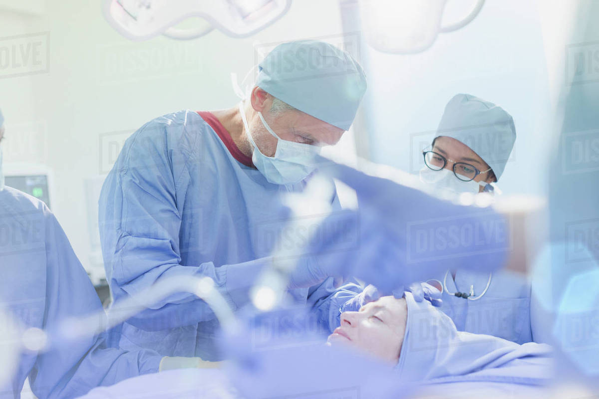 Surgeons operating on female patient in operating room - Stock Photo ...