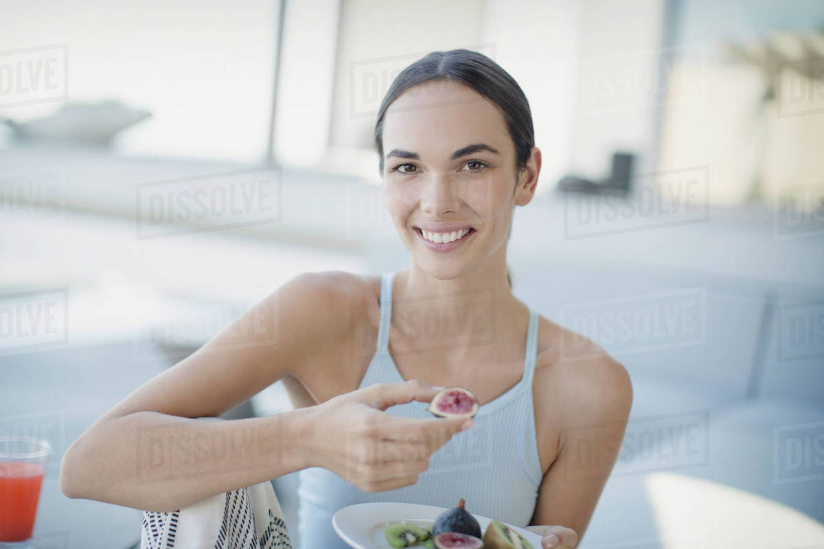Portrait smiling, confident brunette woman eating figs - Royalty-free ...
