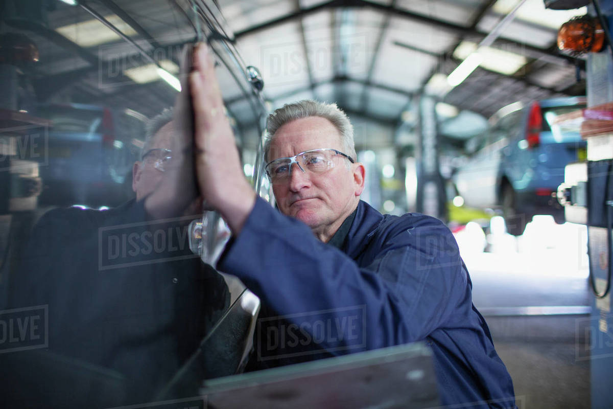 Male mechanic examining car in auto repair shop - Royalty-free Stock ...