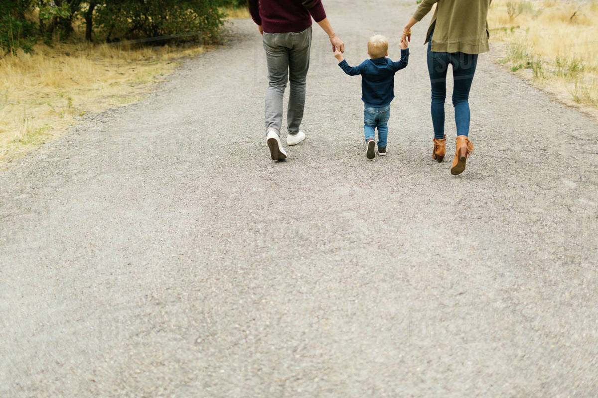 Family walking on rural road together - Royalty-free Stock Photo | Dissolve