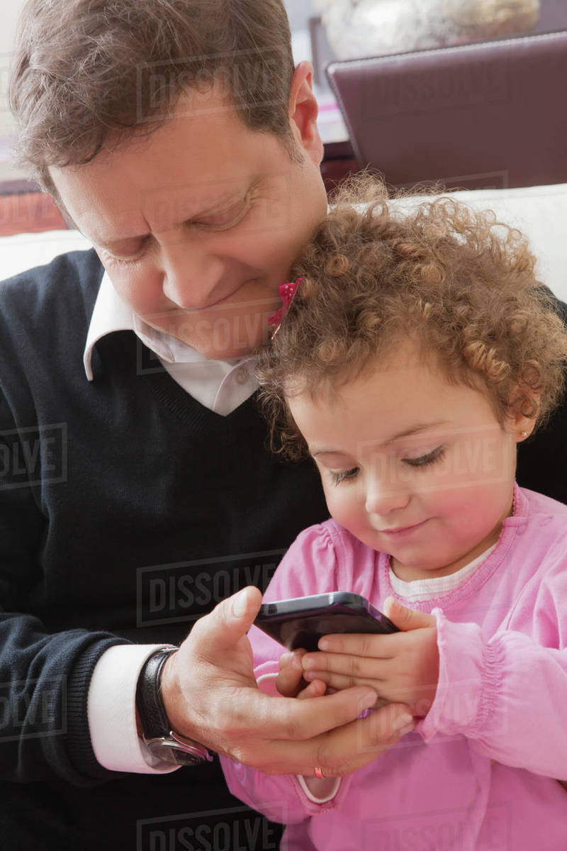 Father and daughter using smart phone - Royalty-free Stock Photo | Dissolve