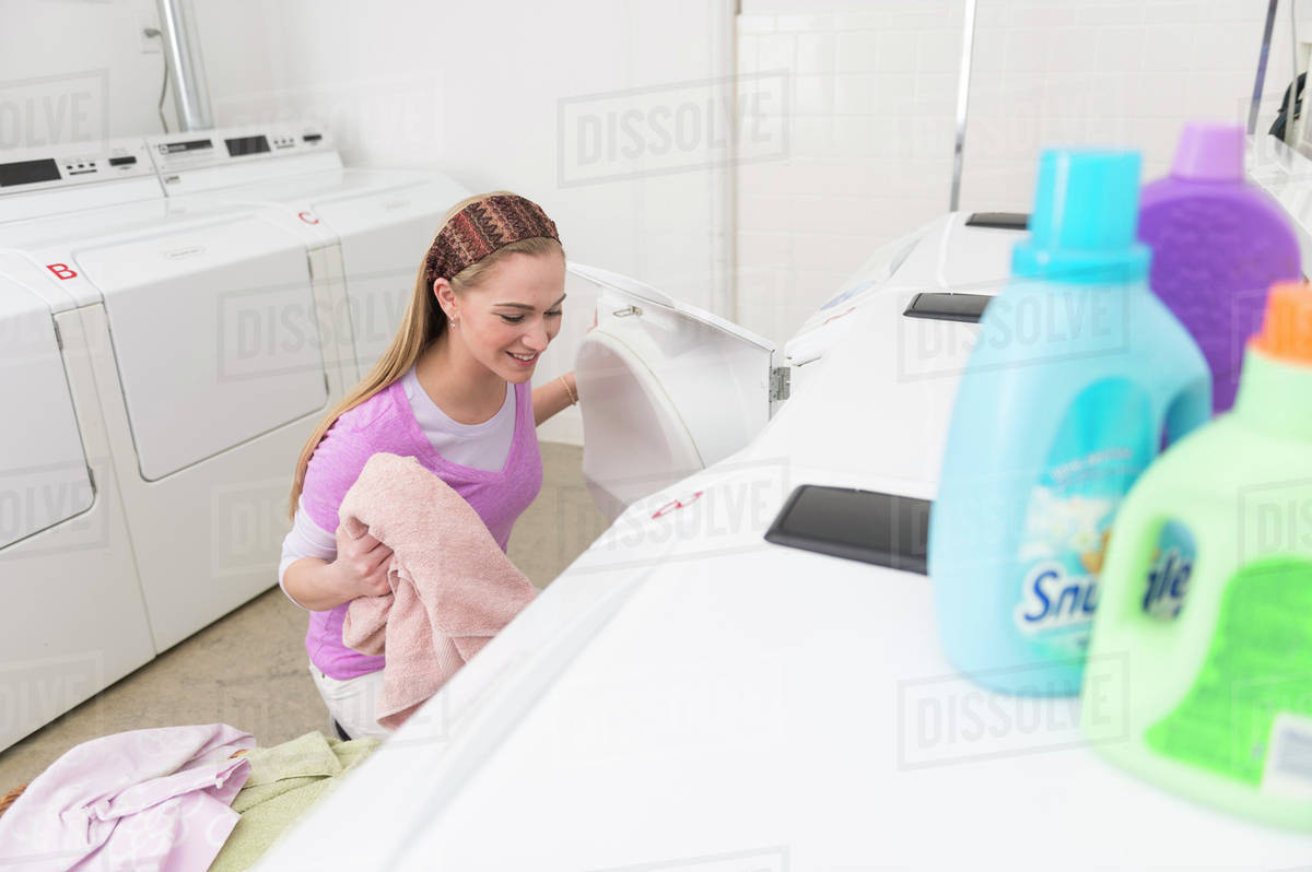 Woman loading laundry into washing machine - Royalty-free Stock Photo ...