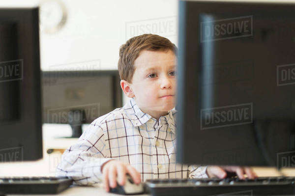 Boy (6-7) using computer - Royalty-free Stock Photo | Dissolve