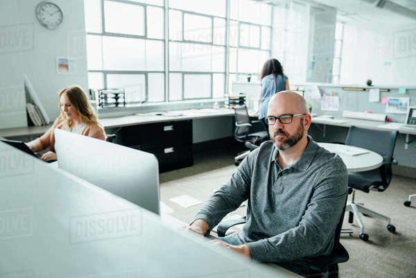 Man using computer in office - Royalty-free Stock Photo | Dissolve