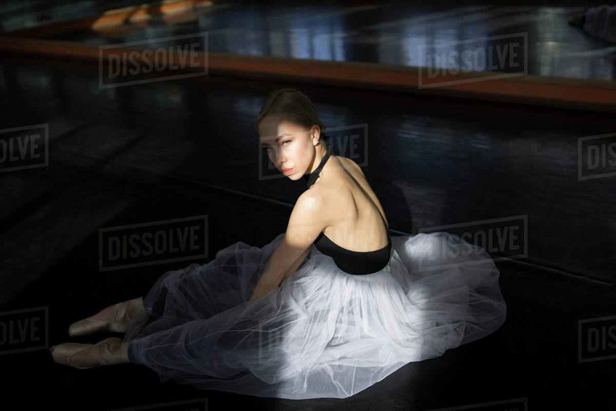 Ballet dancer sitting in shadow - Stock Photo - Dissolve