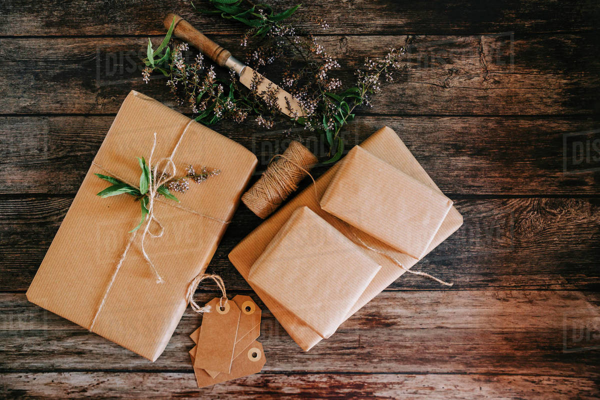 Presents wrapped in brown paper and string with labels and flowers ...