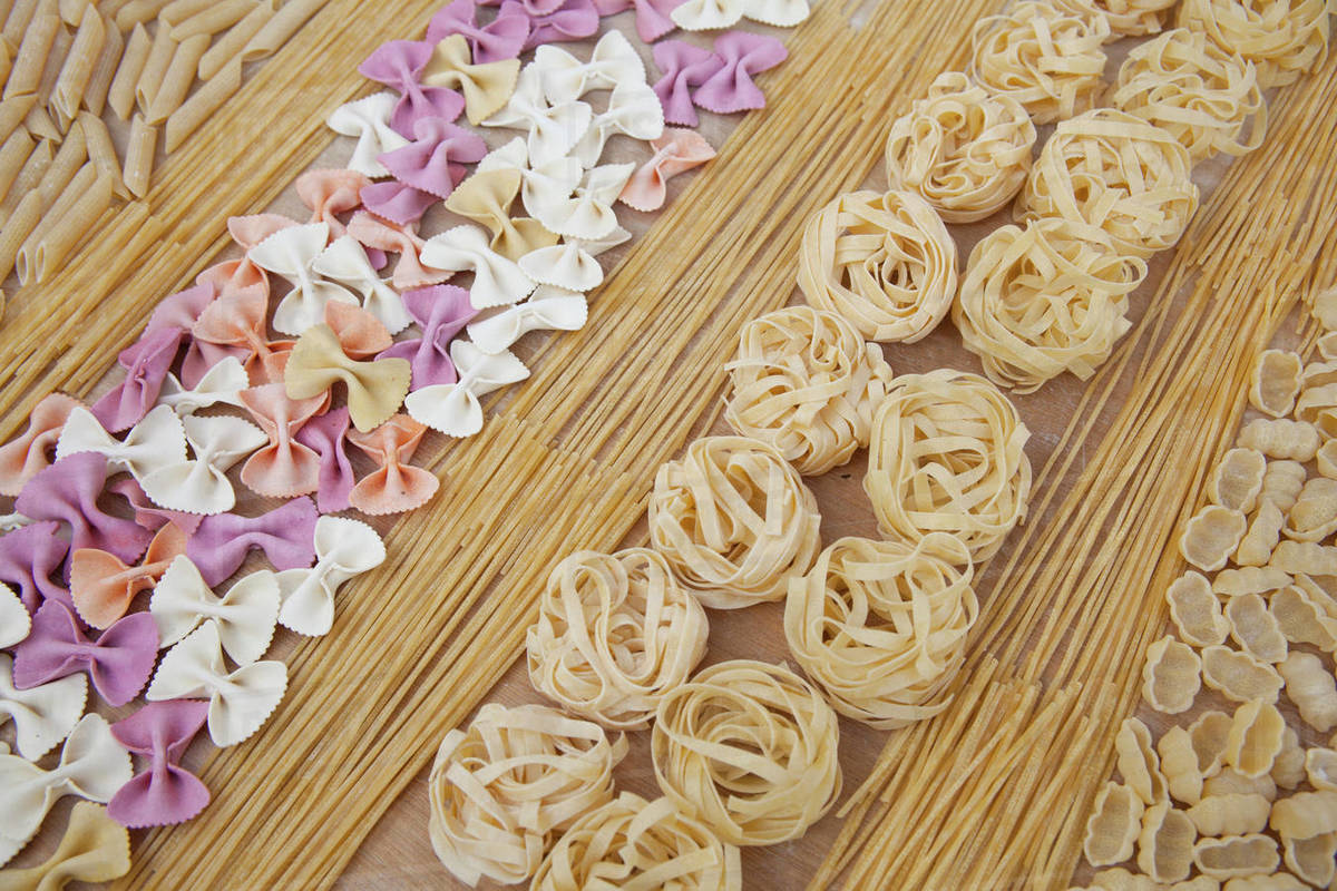 Assorted uncooked pasta in rows - Stock Photo - Dissolve
