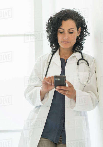 Female doctor using cell phone - Royalty-free Stock Photo | Dissolve