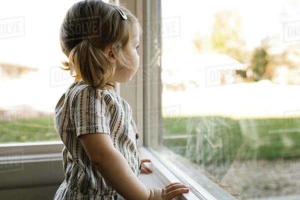 Girl (2-3) looking through window - Royalty-free Stock Photo | Dissolve