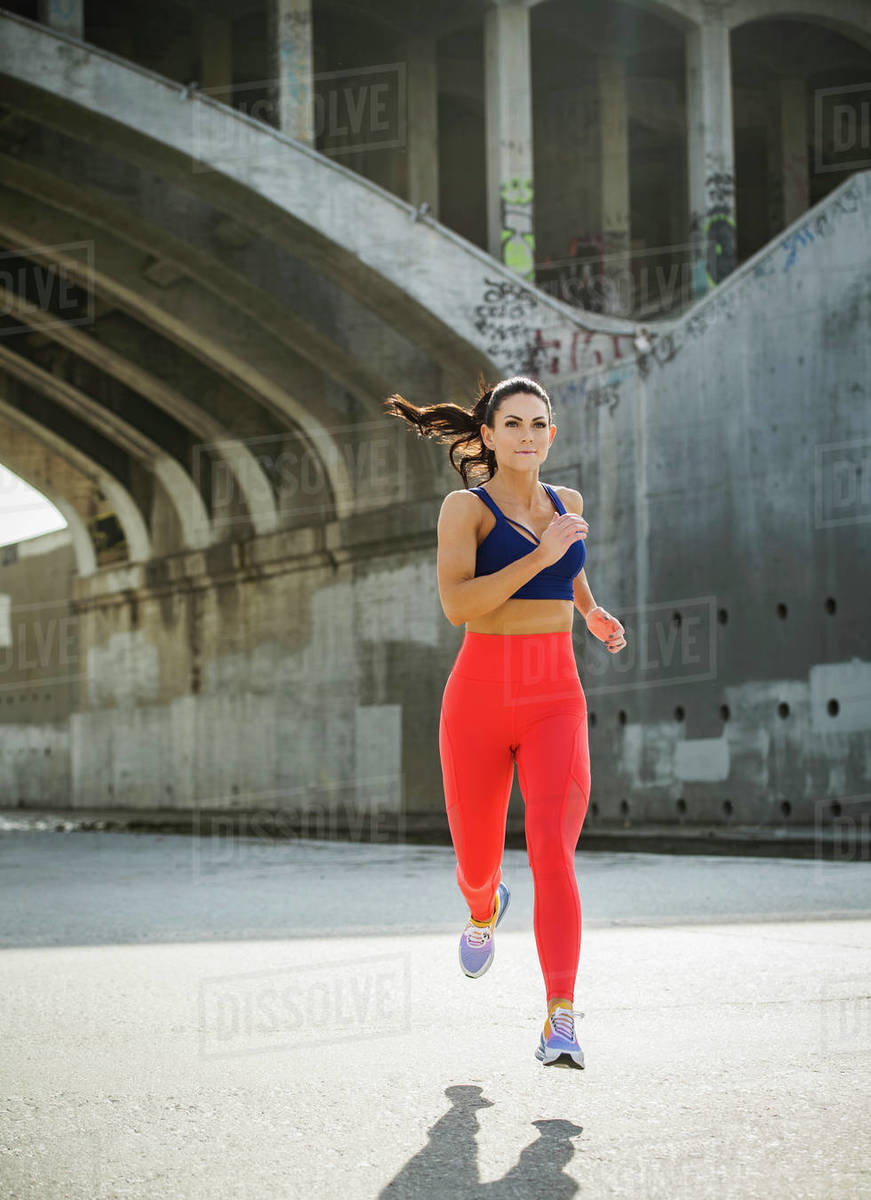 USA, California, Los Angeles, Sporty woman jogging in urban setting ...