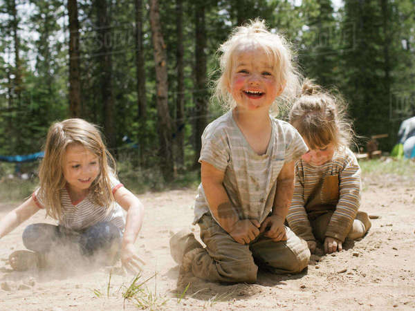Three smiling girls (2-3, 4-5) playing in sand on camping, Wasatch ...