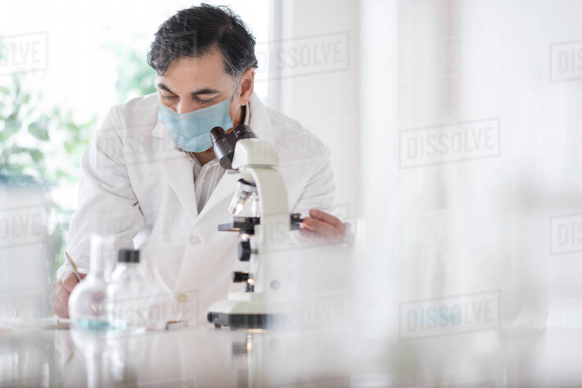 Doctor using microscope - Stock Photo - Dissolve