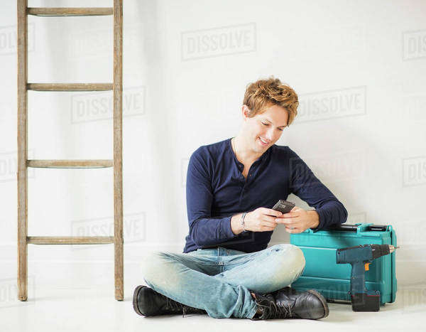 Man with toolbox using phone - Royalty-free Stock Photo | Dissolve