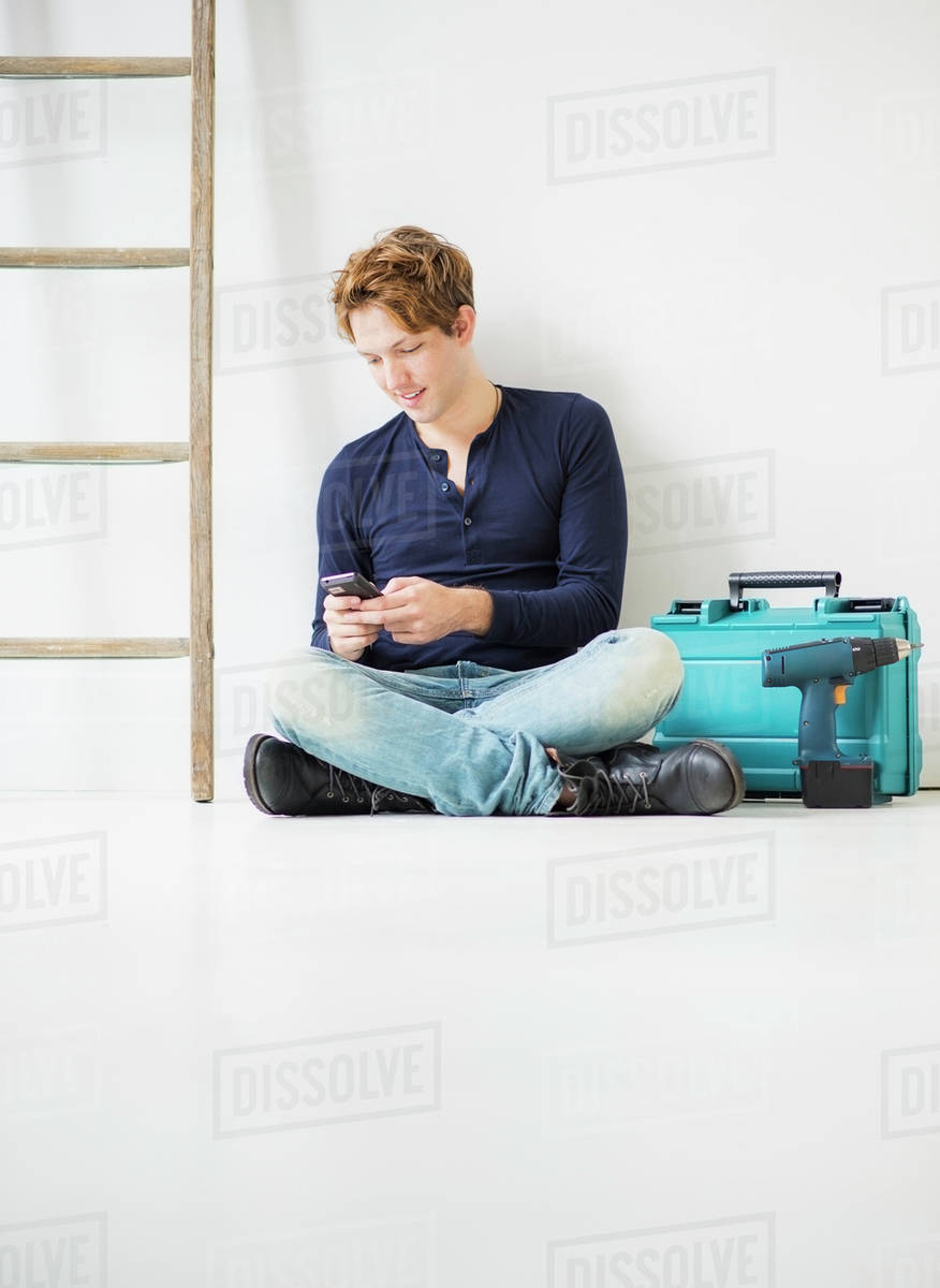 Man with toolbox using phone - Royalty-free Stock Photo | Dissolve