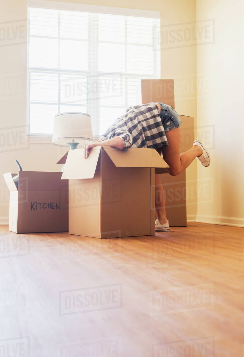 Young woman looking into box in her new house - Royalty-free Stock ...