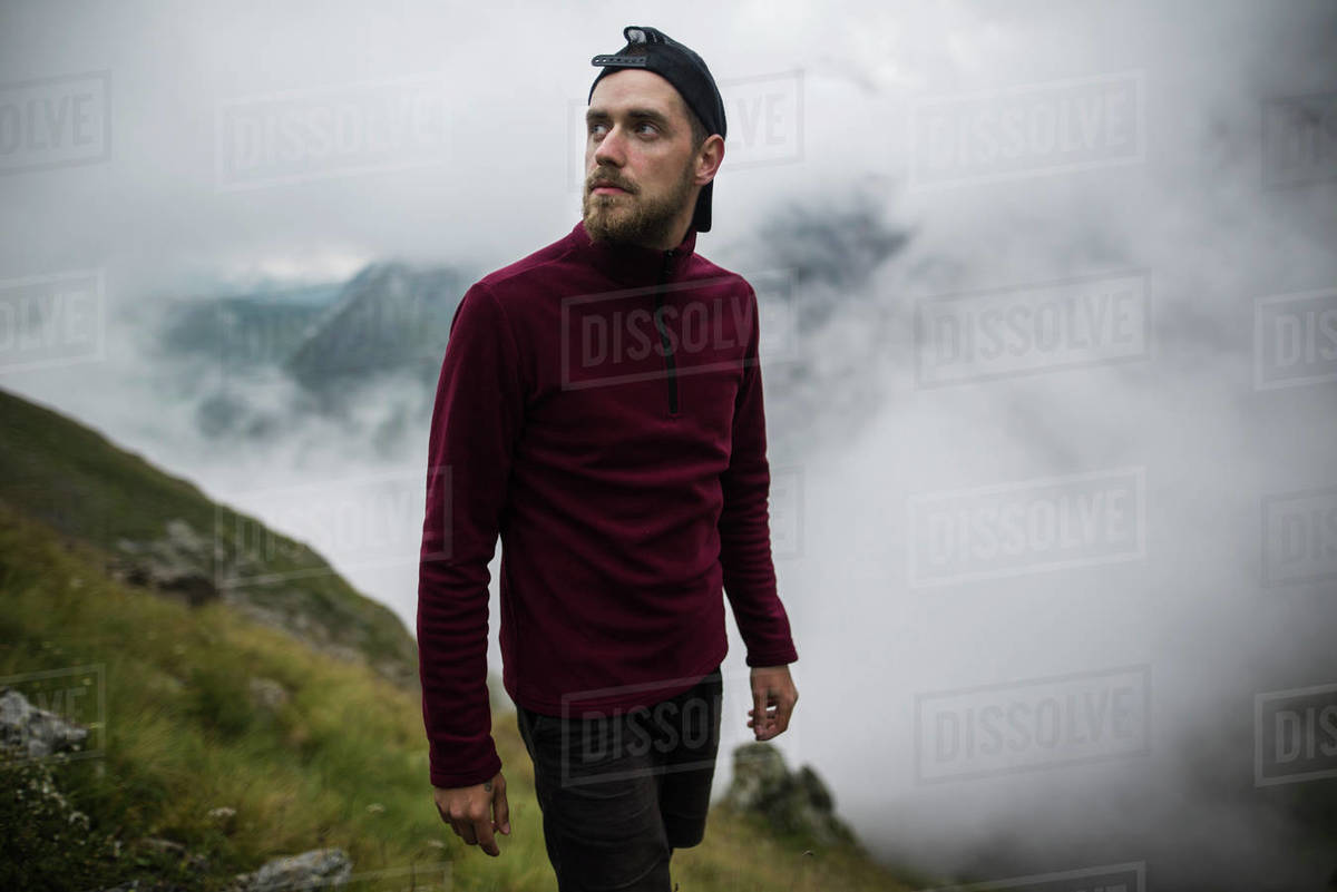 Switzerland, Appenzell, Young man hiking in Swiss Alps - Royalty-free ...