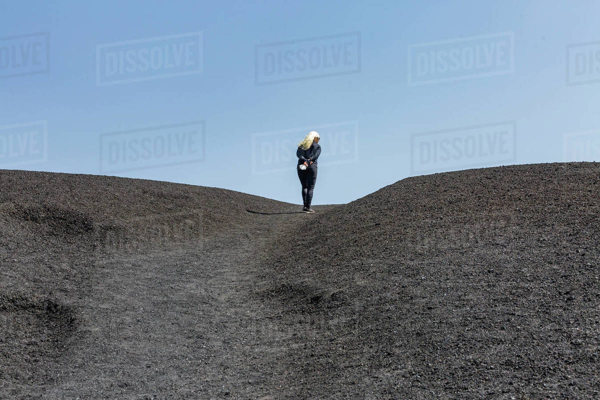 Woman hiking in cinder cone at Craters of the Moon National Monument ...