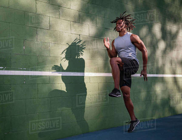 Athletic man jumping next to wall - Royalty-free Stock Photo | Dissolve