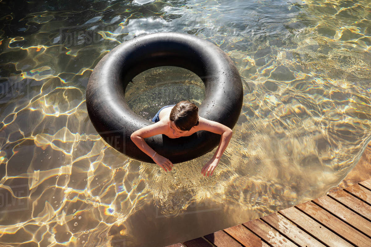 Boy (8-9) in large innertube floating in swimming pool - Stock Photo ...