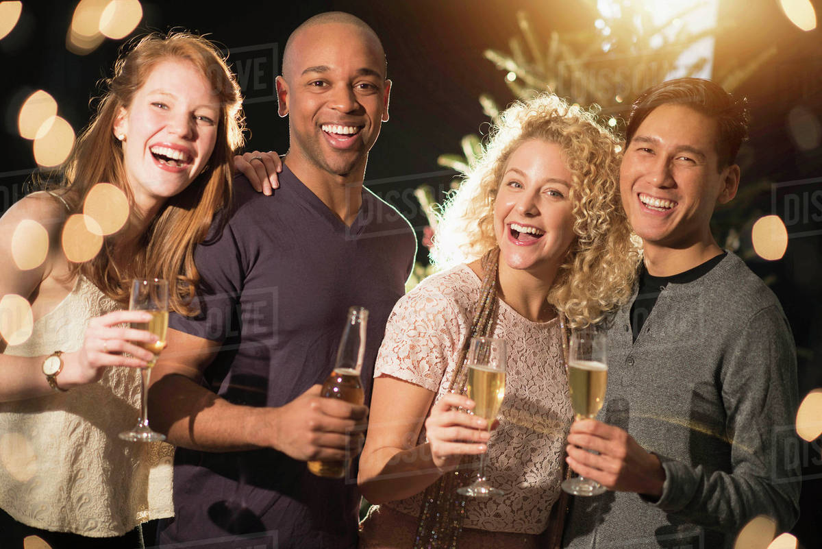 Cheerful friends celebrating New Year's Eve - Stock Photo - Dissolve