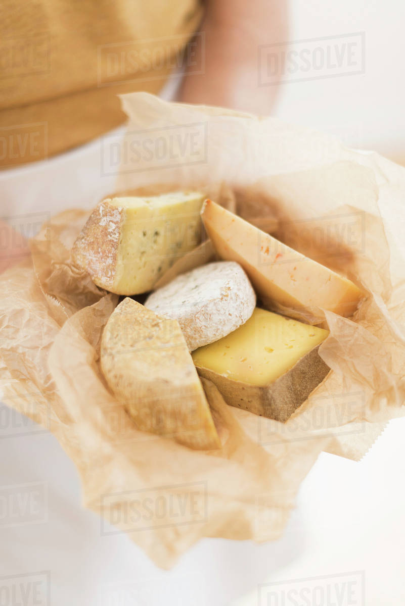 Close up of man's hand holding slices of cheese in paper - Royalty-free ...