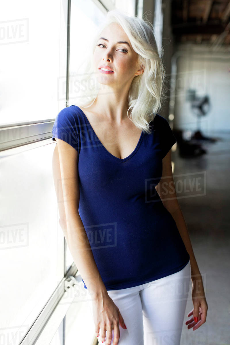 Woman standing by window - Royalty-free Stock Photo | Dissolve