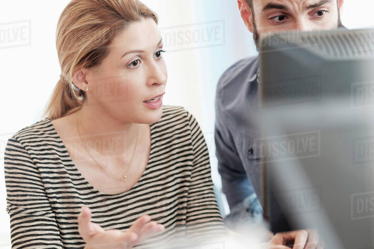Man and woman looking at computer - Royalty-free Stock Photo | Dissolve