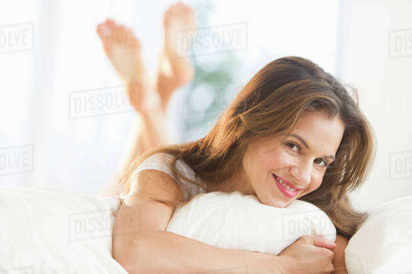 Happy woman lying on bed - Royalty-free Stock Photo | Dissolve