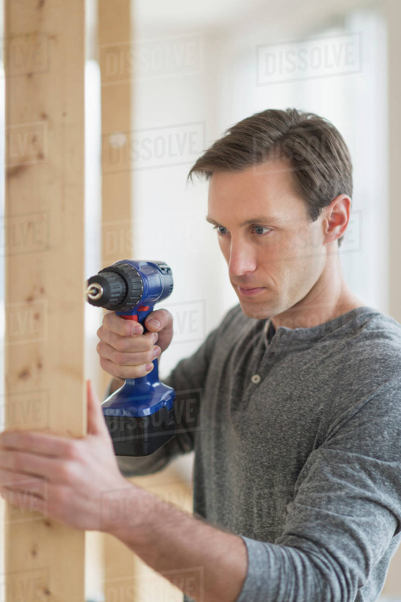 Man using hand drill - Stock Photo - Dissolve