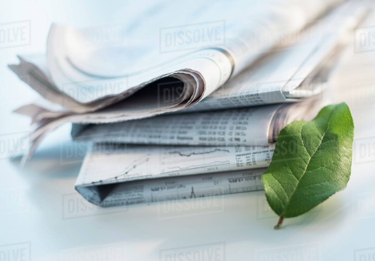 Studio shot of newspaper and green leaf - Royalty-free Stock Photo ...