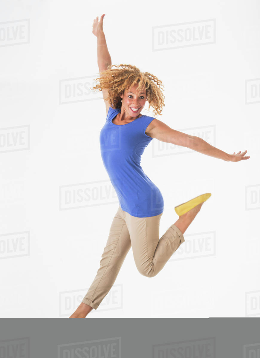 Woman jumping, studio shot - Royalty-free Stock Photo | Dissolve