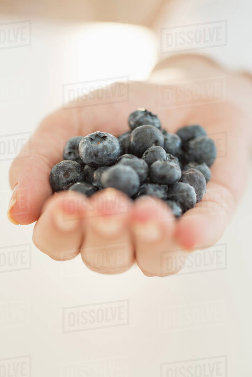 Blueberries on woman's hand - Royalty-free Stock Photo | Dissolve